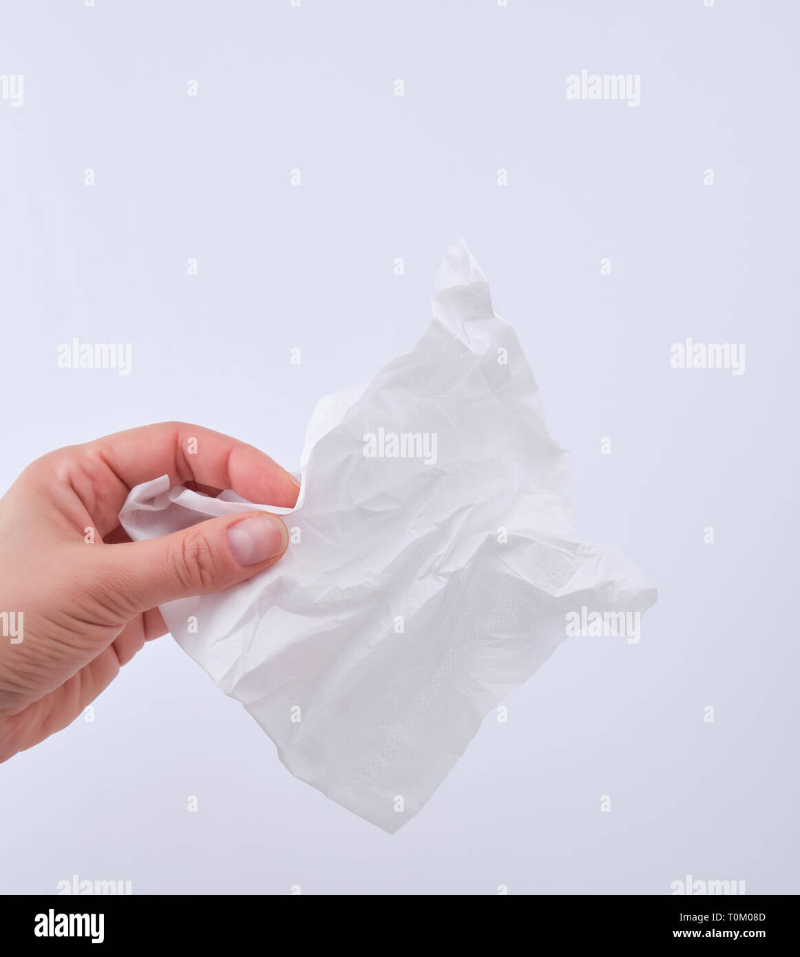 female hand holding a clean white paper napkin for face and body, white ...