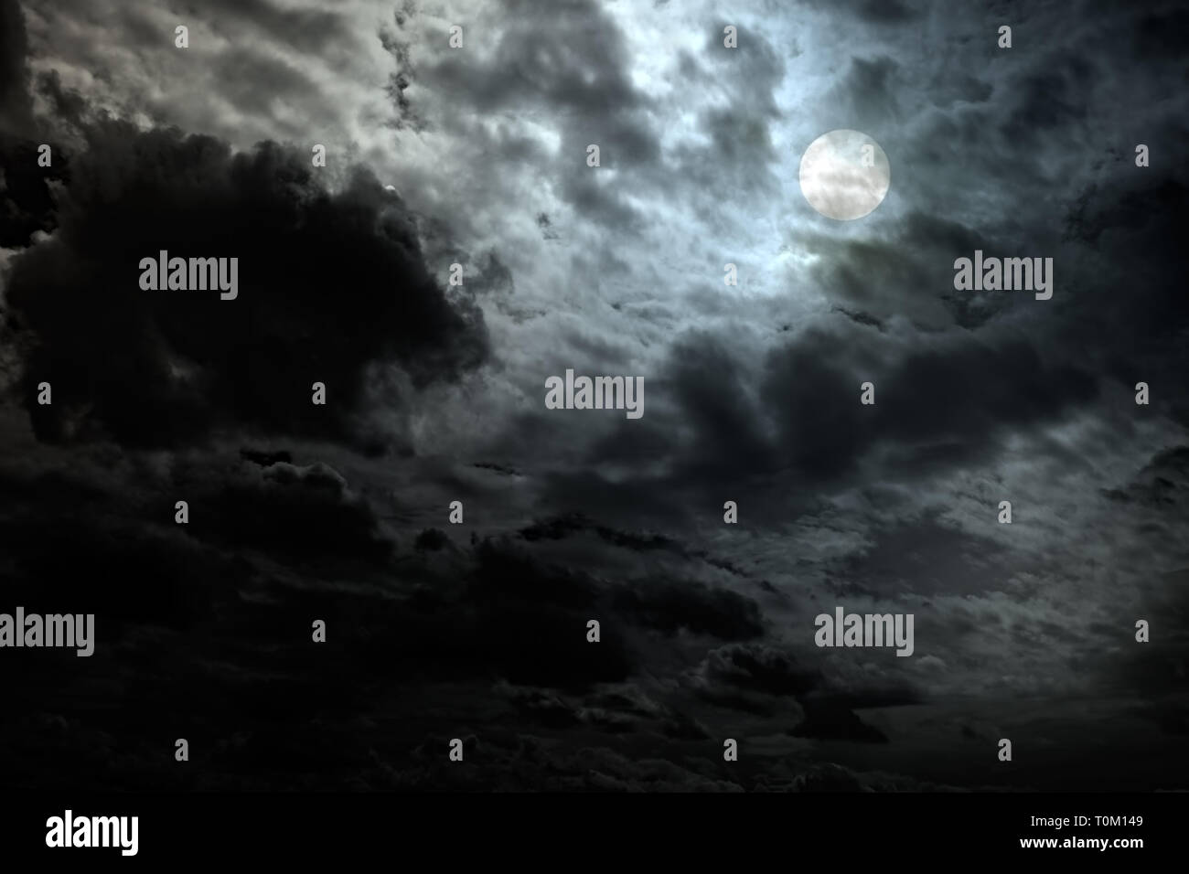 Cloudy full moon night with interesting light Stock Photo - Alamy