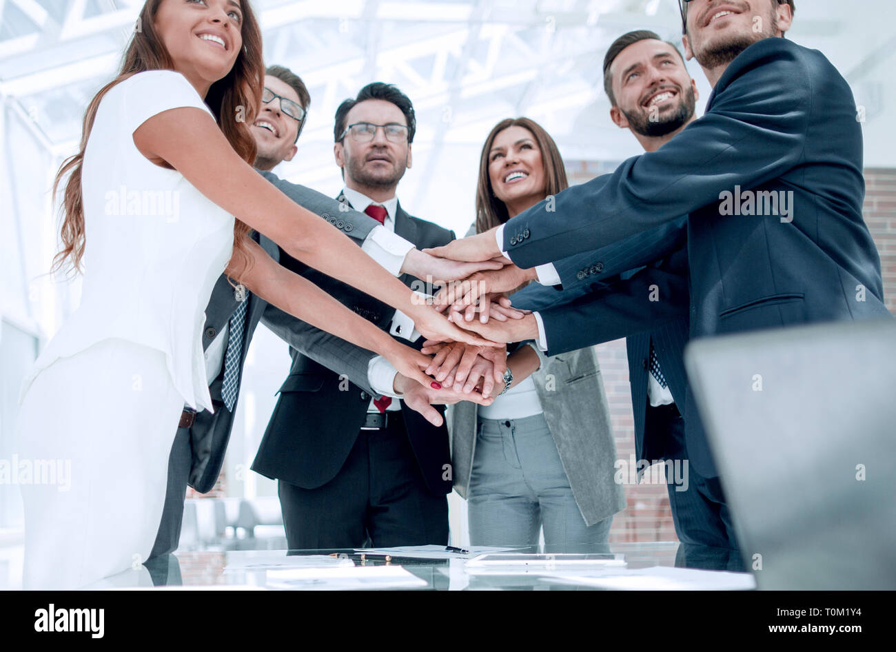 happy business team joining their hands together Stock Photo - Alamy
