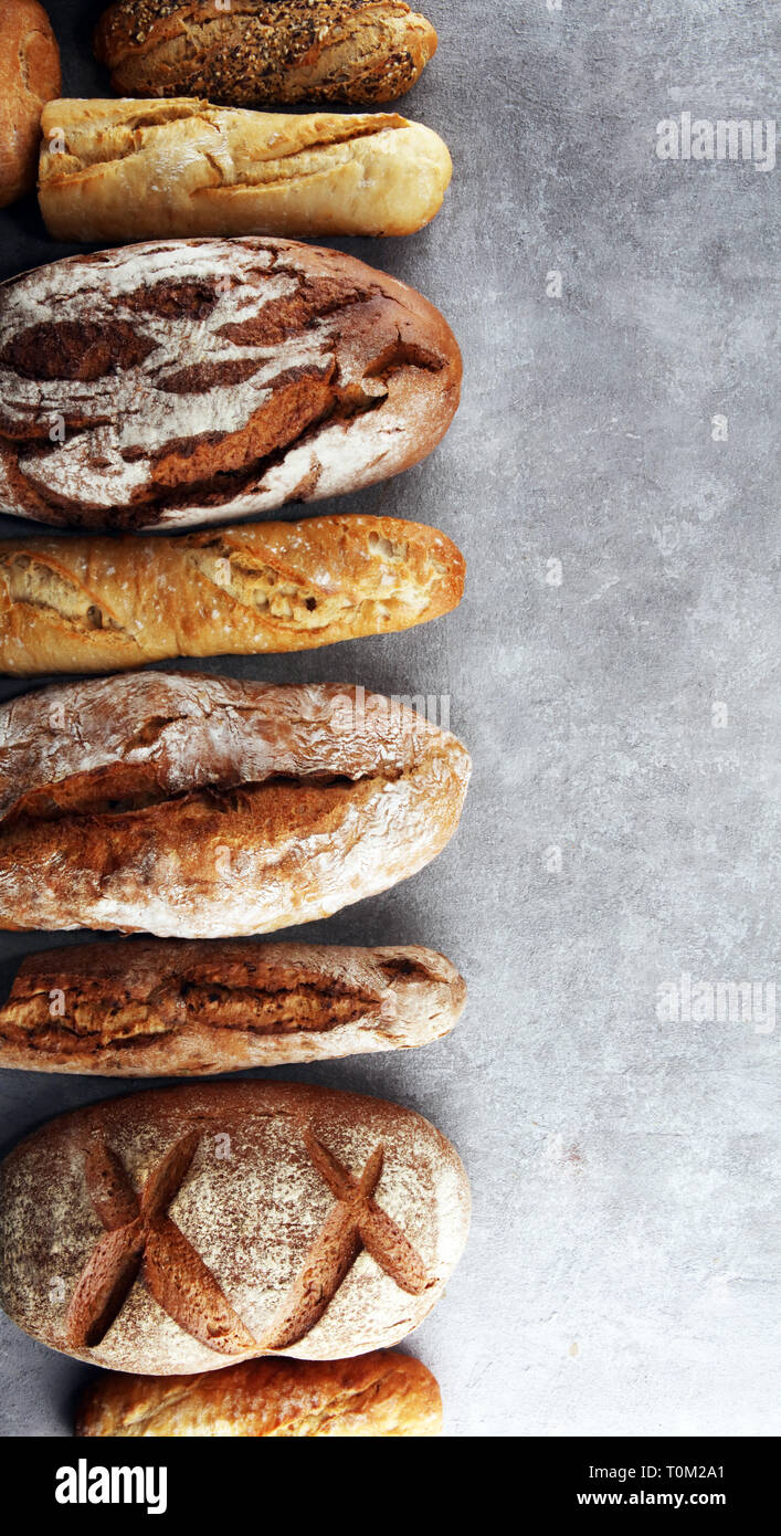 Assortment of baked bread and bread rolls on stone table background ...
