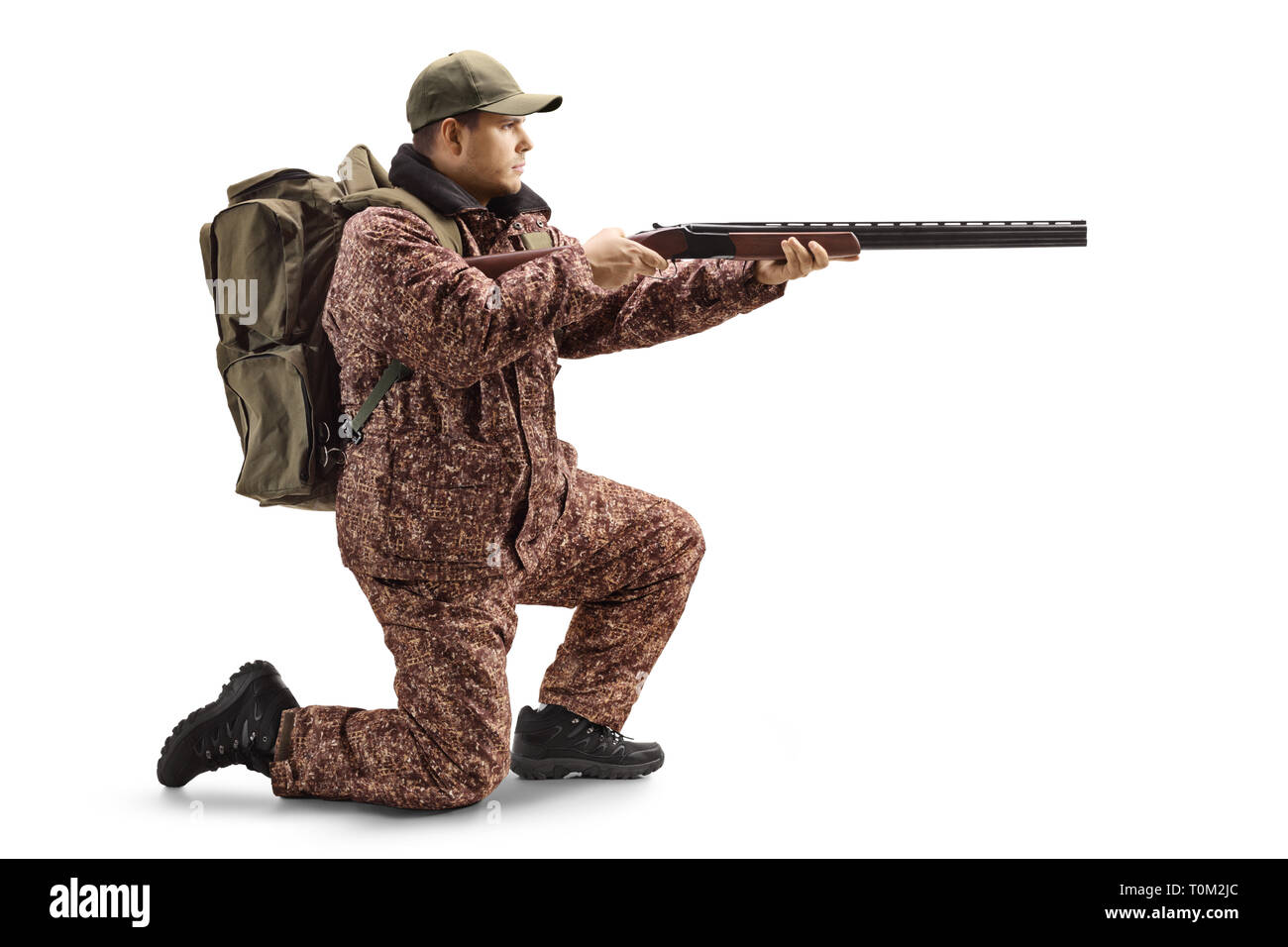 Full length profile shot of a man hunter in a uniform kneeling and ...