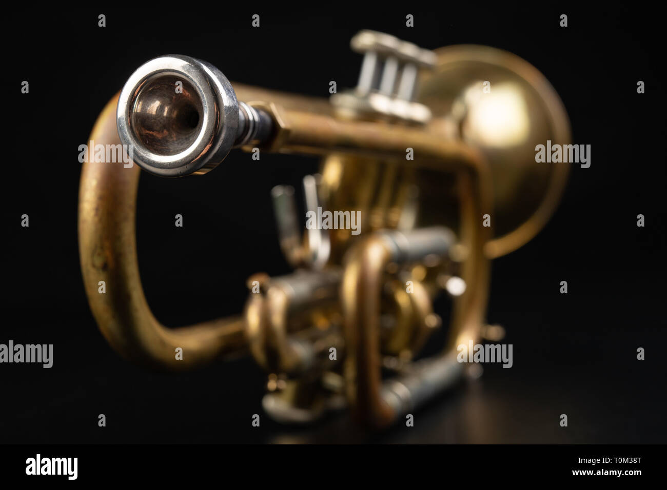 Old coated patina trumpet on a dark table. An inedible musical ...