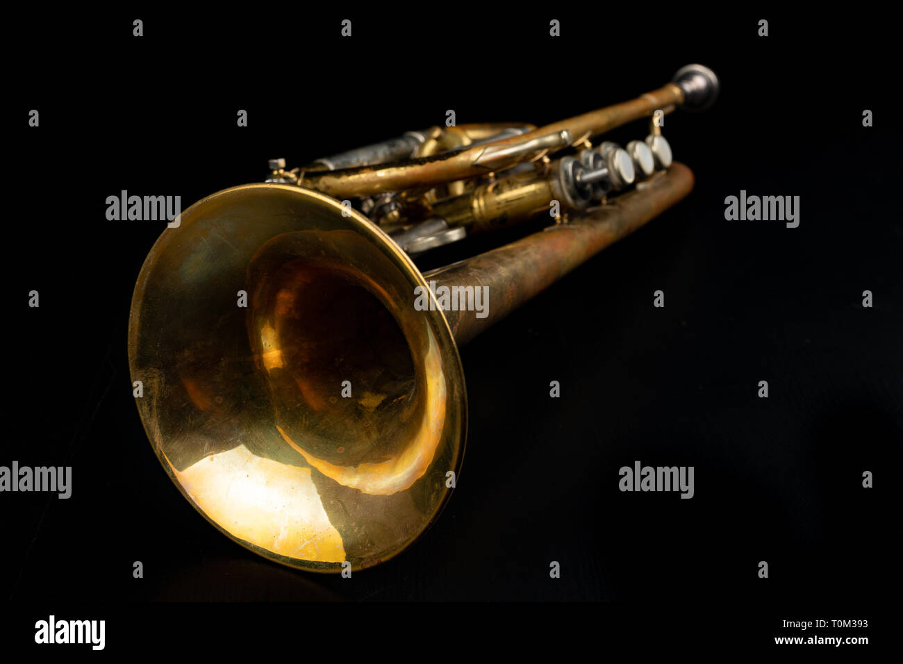 Old coated patina trumpet on a dark table. An inedible musical ...