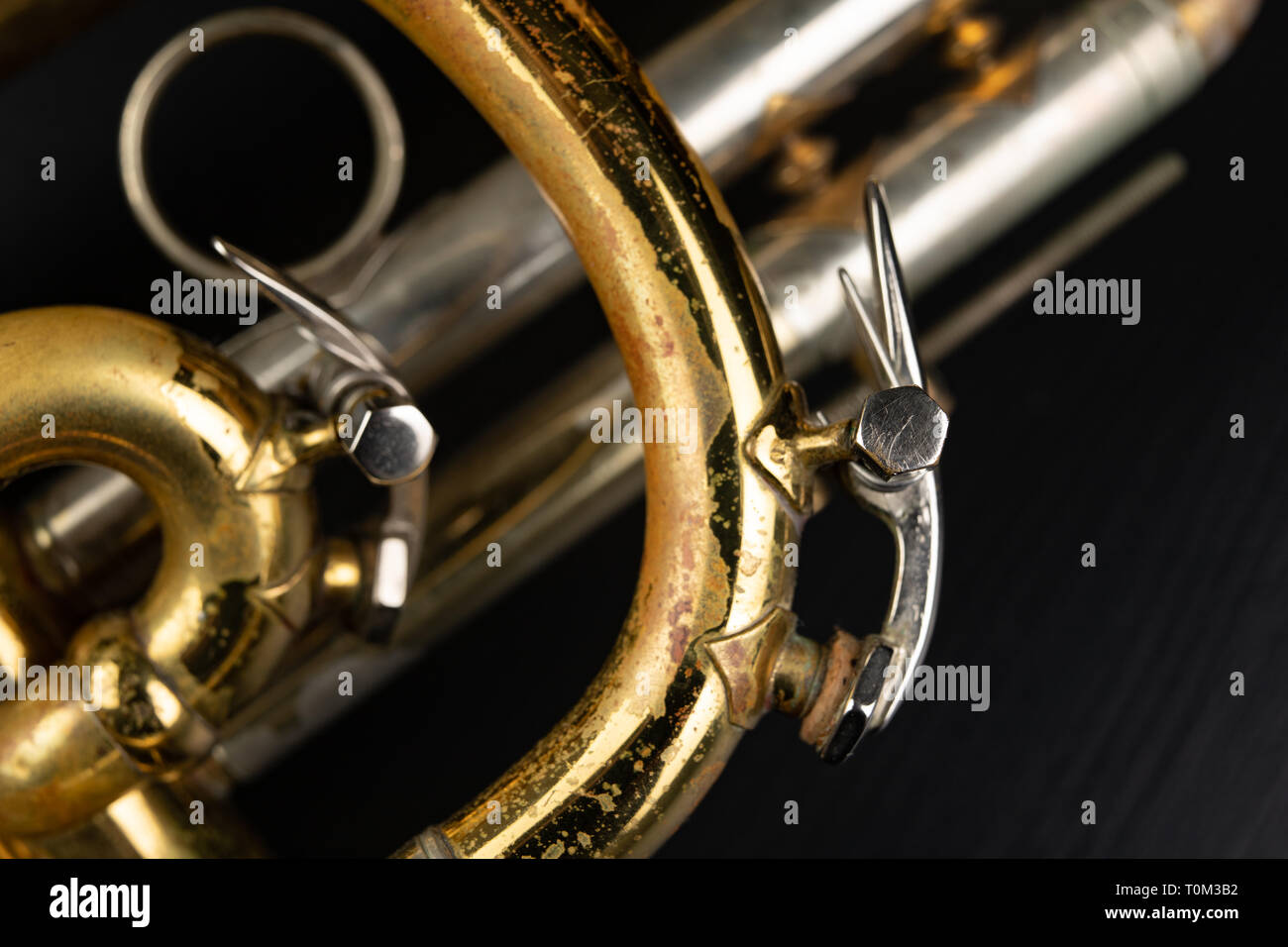 Old coated patina trumpet on a dark table. An inedible musical ...