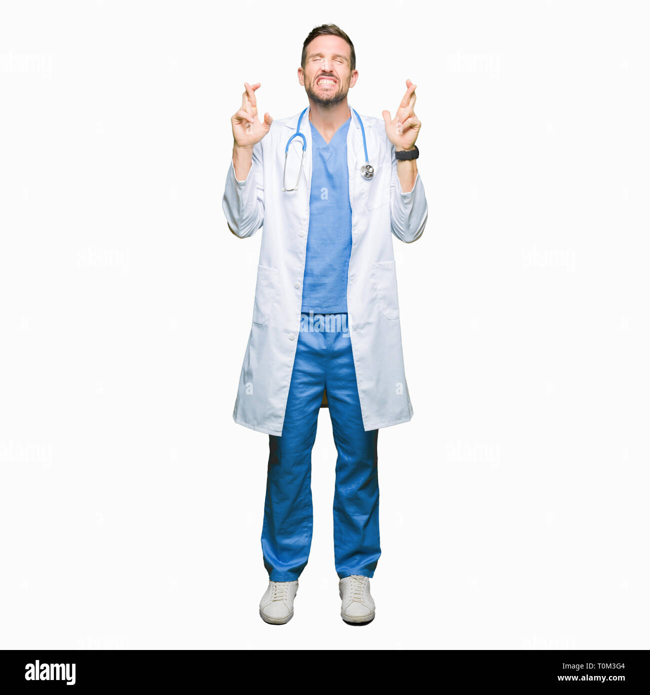 Hopeful young man crossing fingers Cut Out Stock Images & Pictures - Alamy