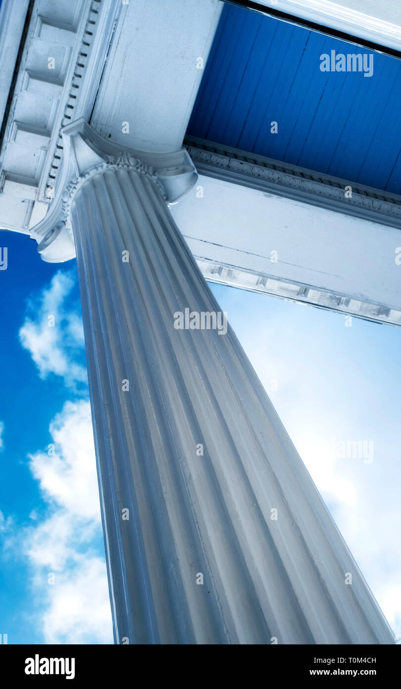 A white pillar holding a covered entrance way to an old house blocking ...