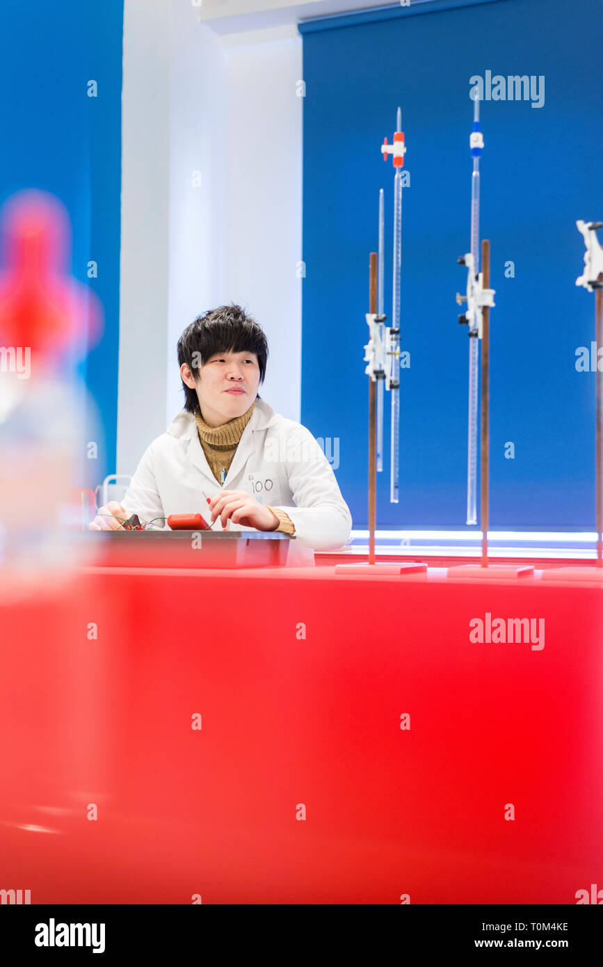 A young overseas international Asian college student in the science lab ...