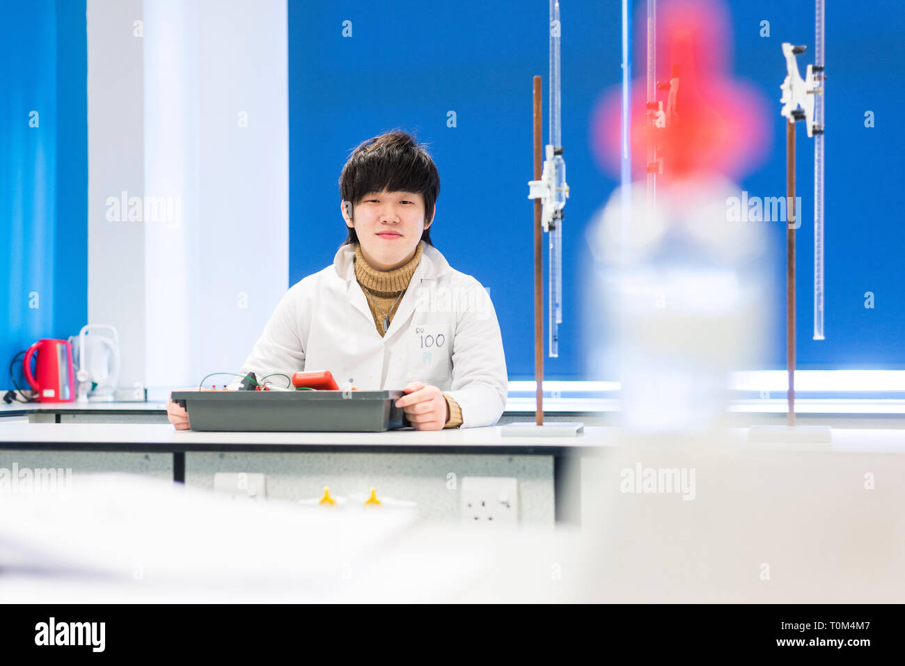 A young overseas international Asian college student in the science lab ...