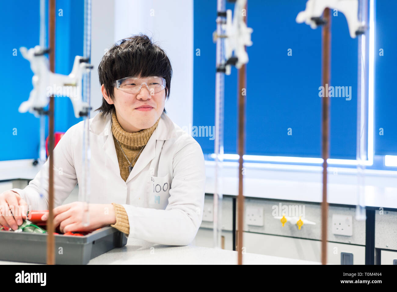 A young overseas international Asian college student in the science lab ...