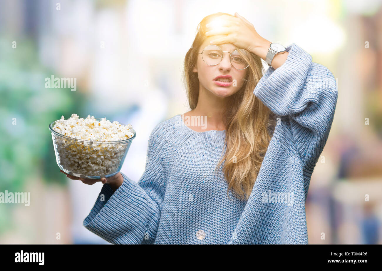 Young beautiful blonde woman eating popcorn over isolated background ...