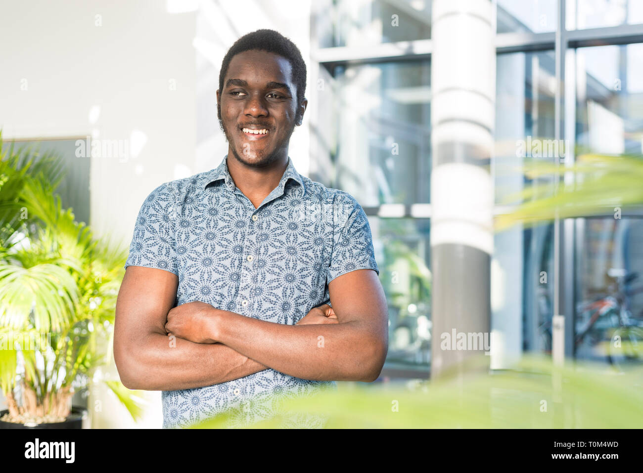 A young black international student stands in the corridors on campus ...