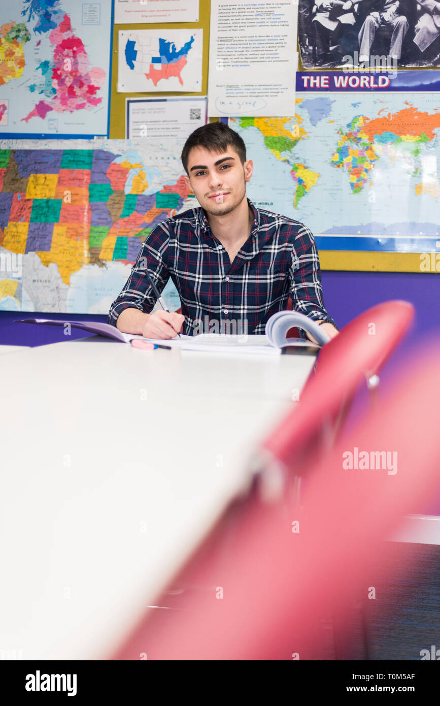 A young middle eastern student sits at a desk during a lesson and ...