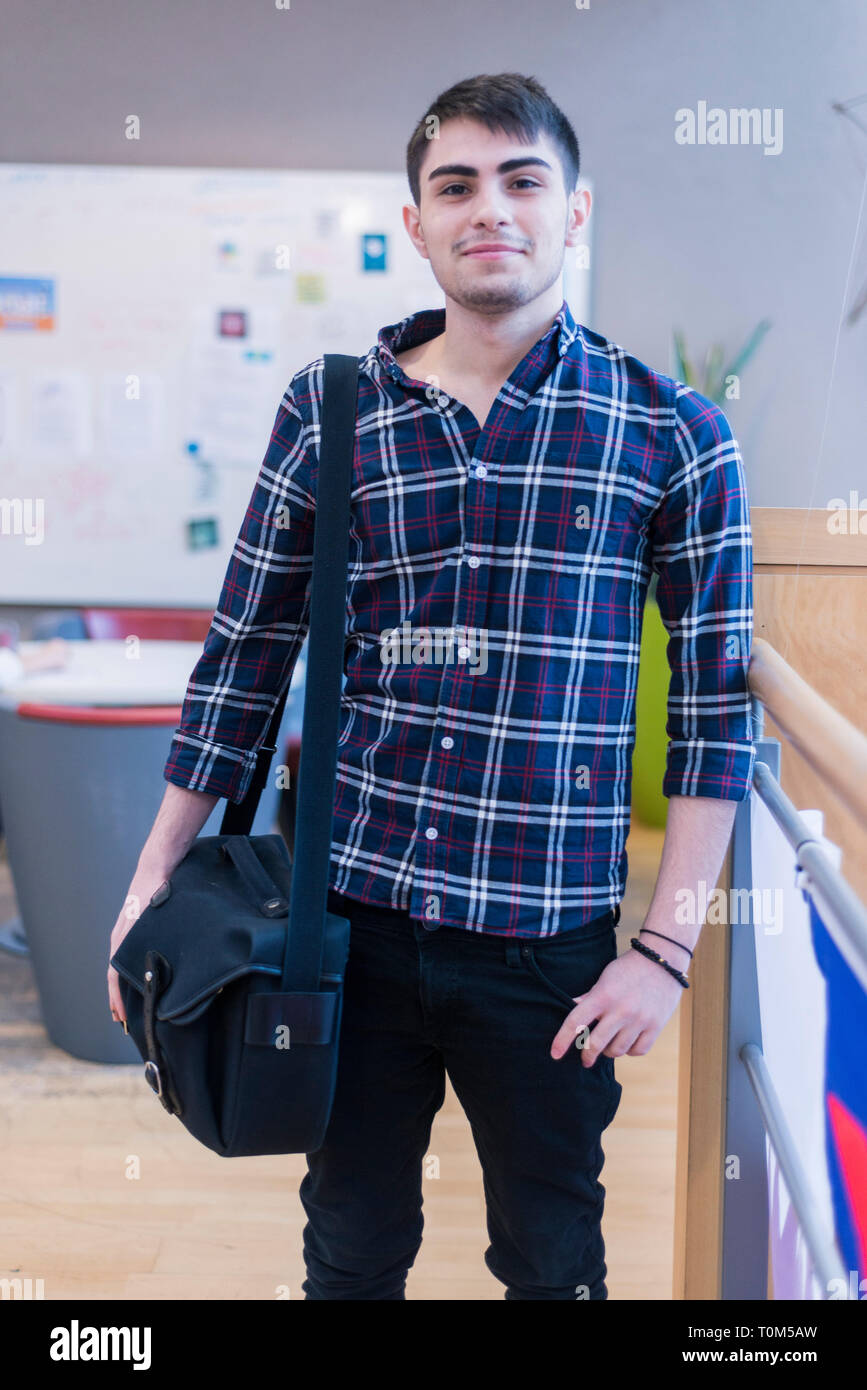 A young middle eastern student sits at a desk during a lesson and ...