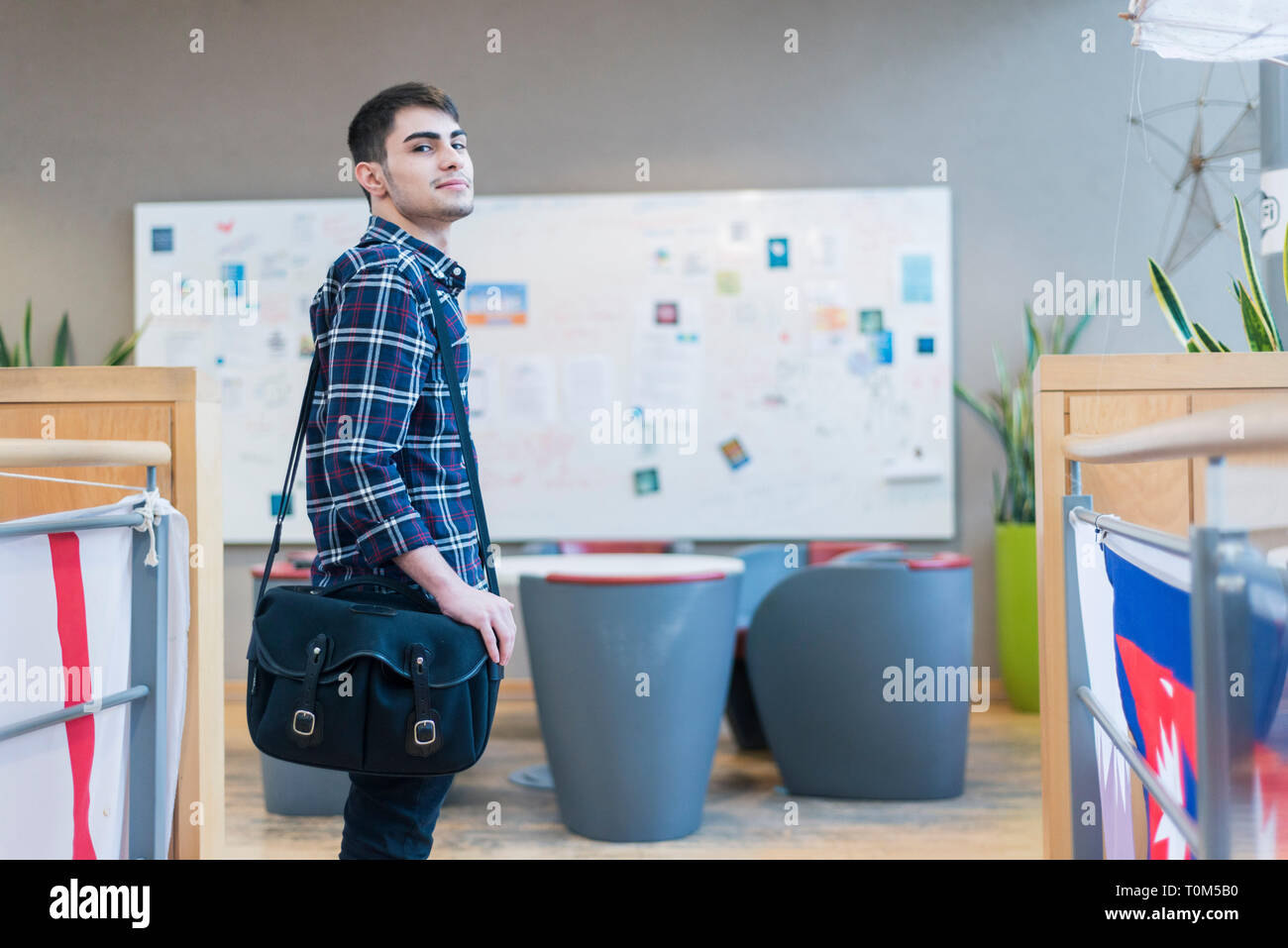 A young middle eastern student sits at a desk during a lesson and ...