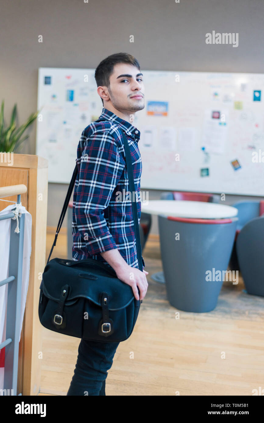 A young middle eastern student sits at a desk during a lesson and ...