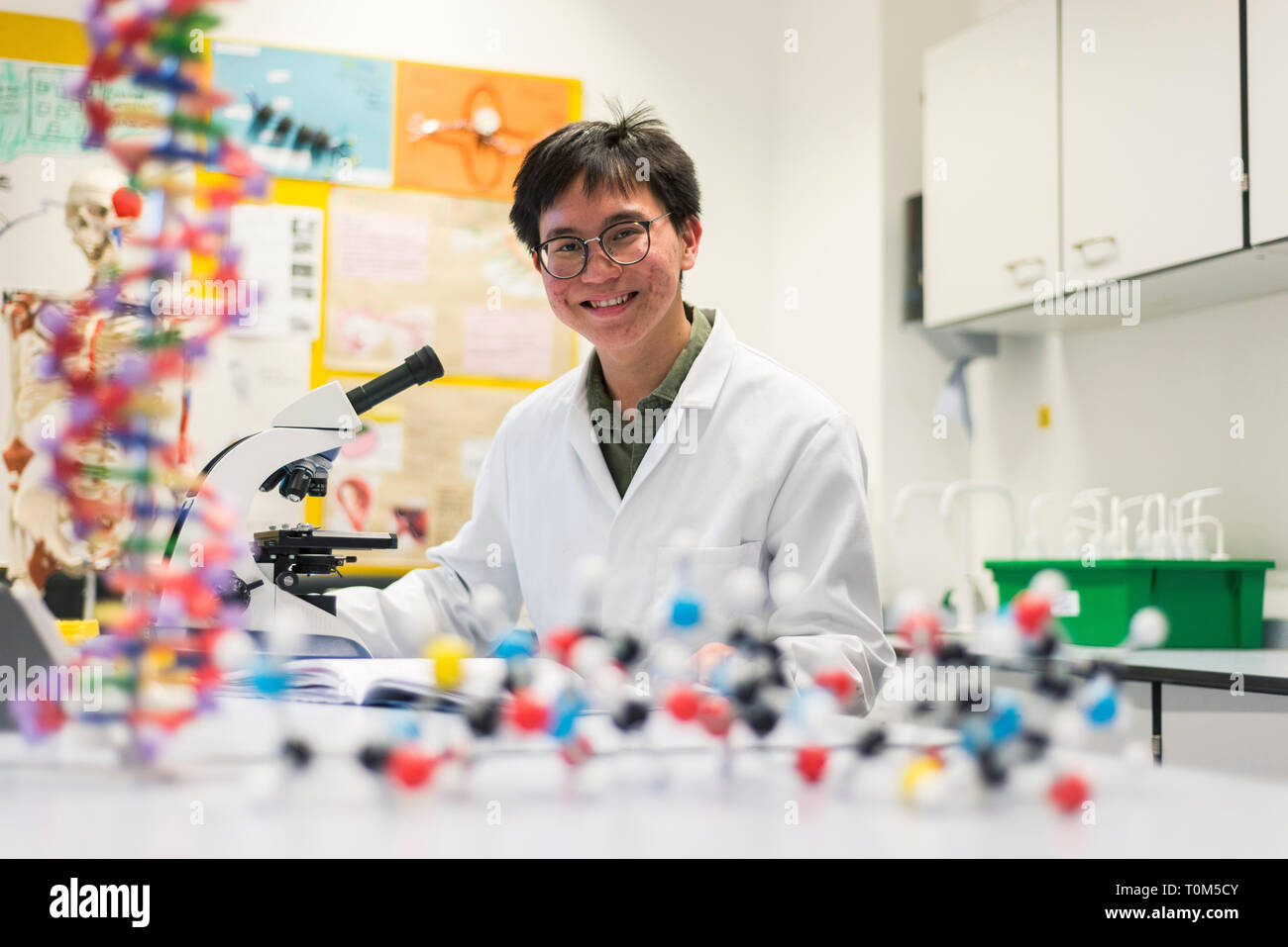 A young overseas international Asian college student in the science lab ...