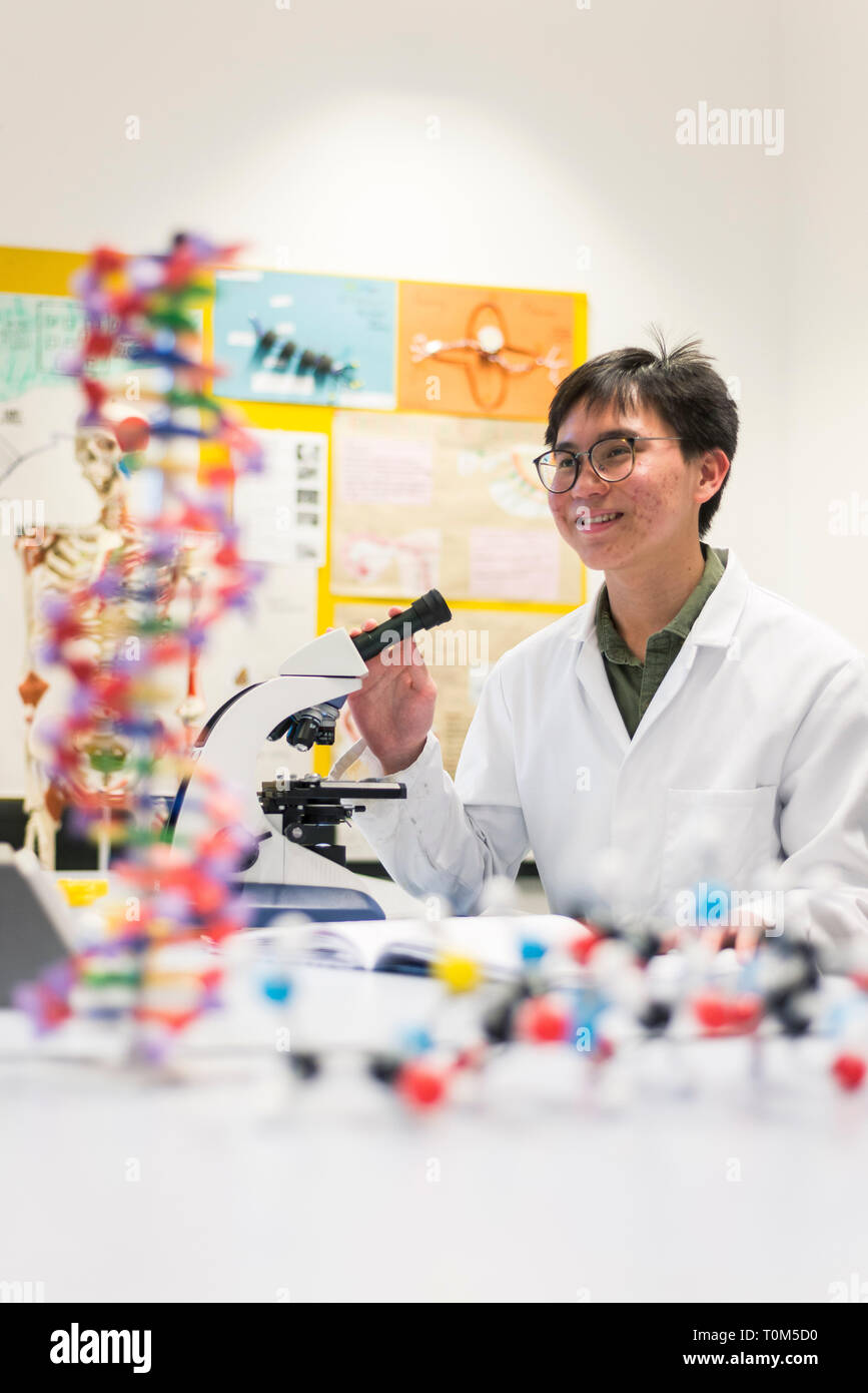 A young overseas international Asian college student in the science lab ...