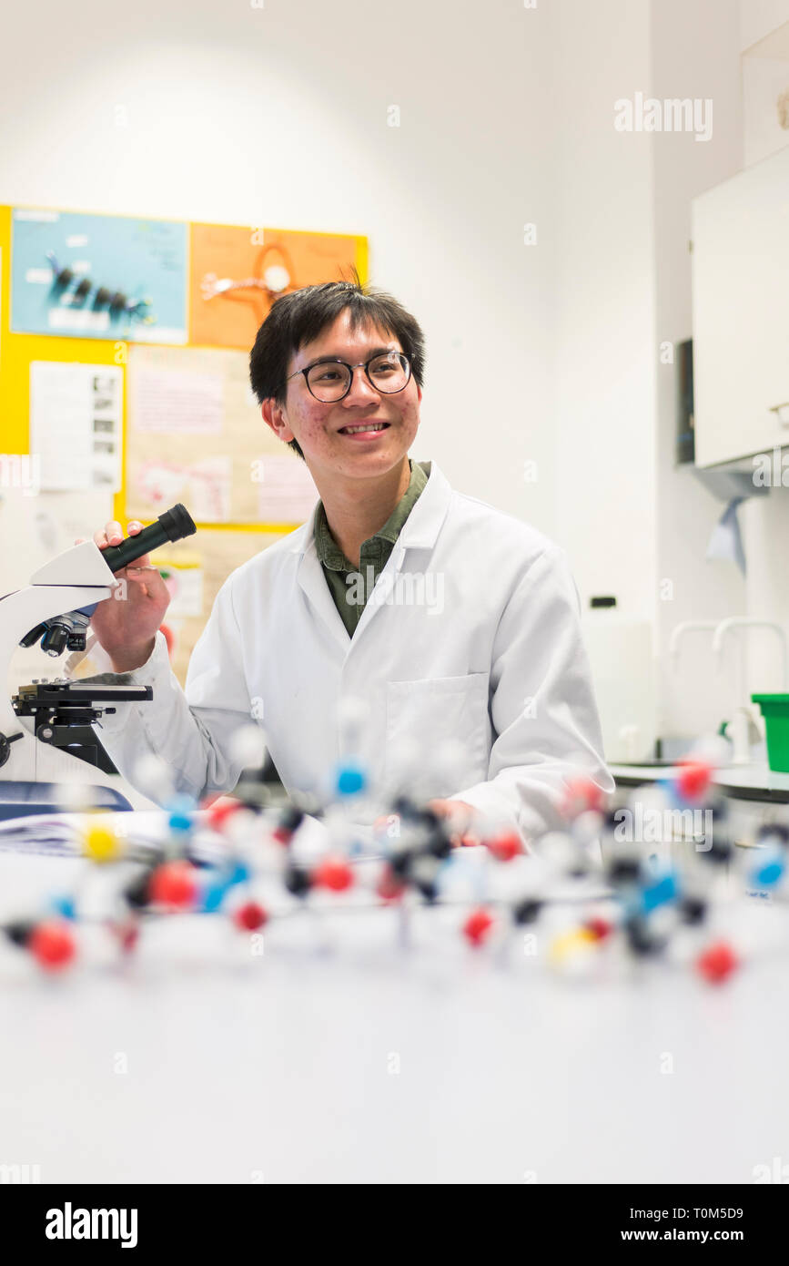 A young overseas international Asian college student in the science lab ...