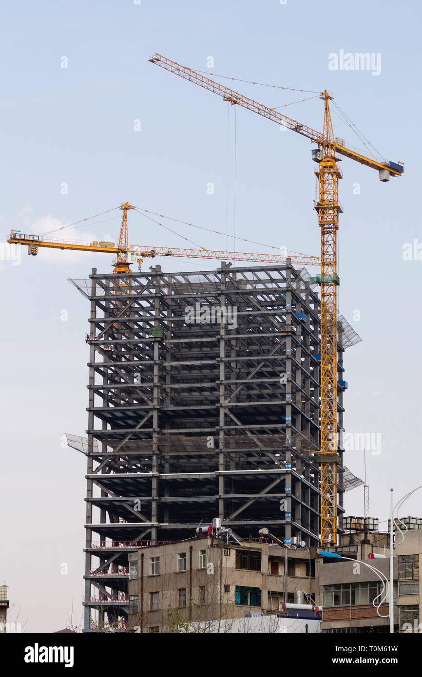 Tall building under construction with scaffolding and tower crane Stock ...