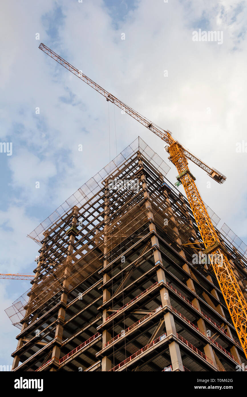 Tall building under construction with scaffolding and tower crane Stock ...