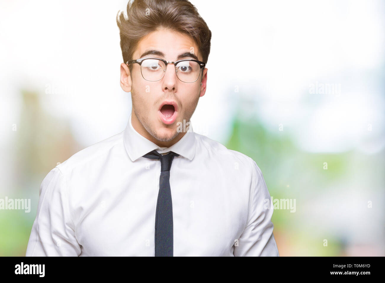 Young business man wearing glasses over isolated background In shock ...