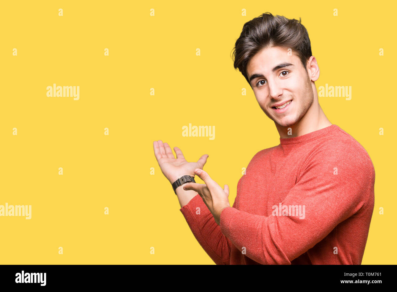 Young handsome man over isolated background Inviting to enter smiling ...