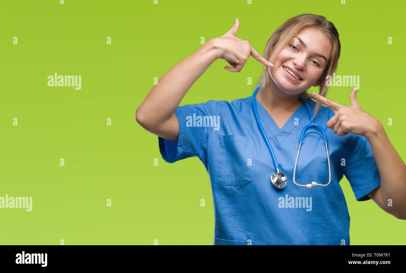 Young caucasian doctor woman wearing surgeon uniform over isolated ...