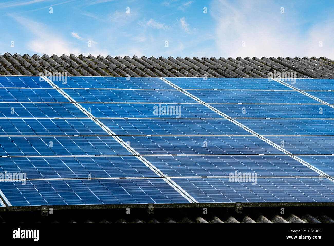 Sun panels on a roof in bright daylight under a blue sky Stock Photo ...
