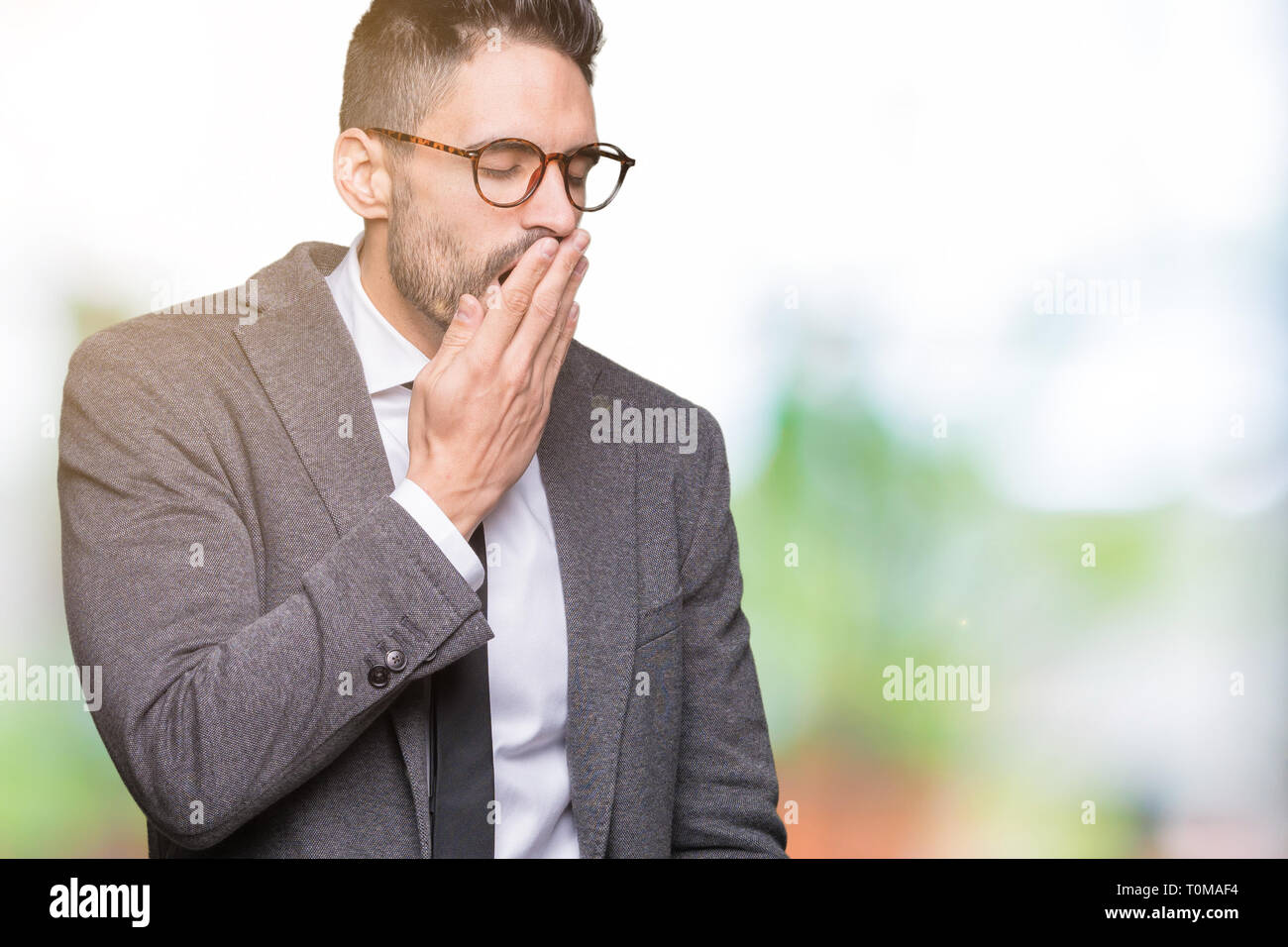 Young handsome business man over isolated background bored yawning ...