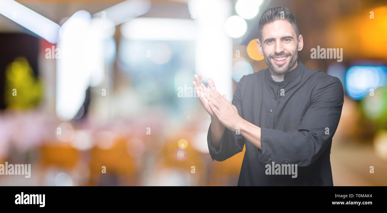 Young Christian priest over isolated background Clapping and applauding ...