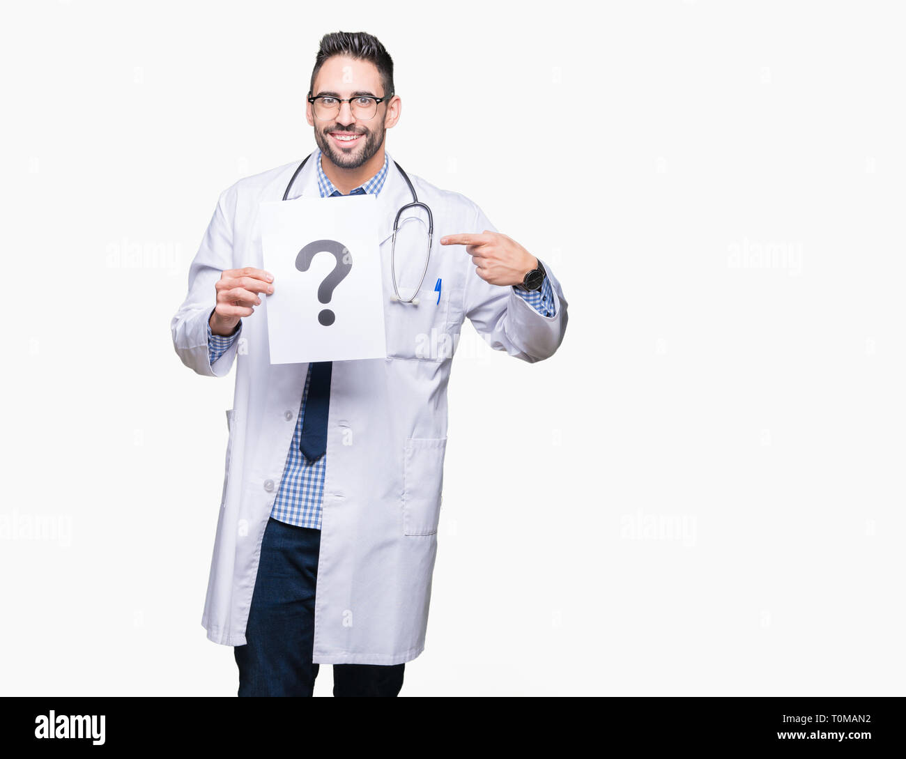 Handsome young doctor man holding paper with question mark over ...