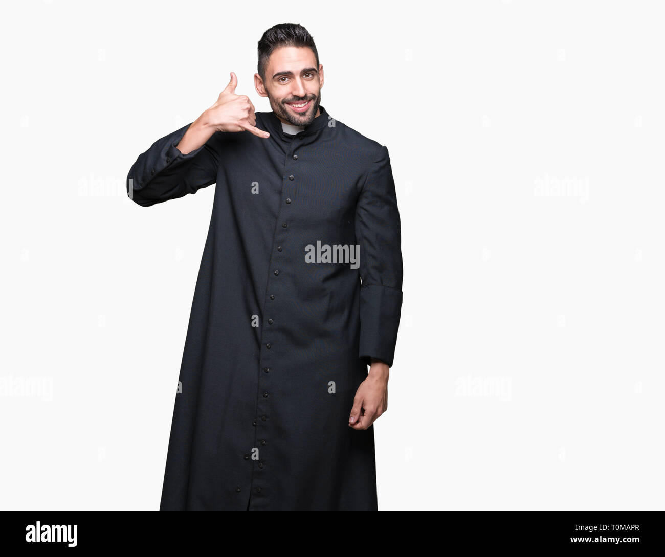 Young Christian priest over isolated background smiling doing phone ...