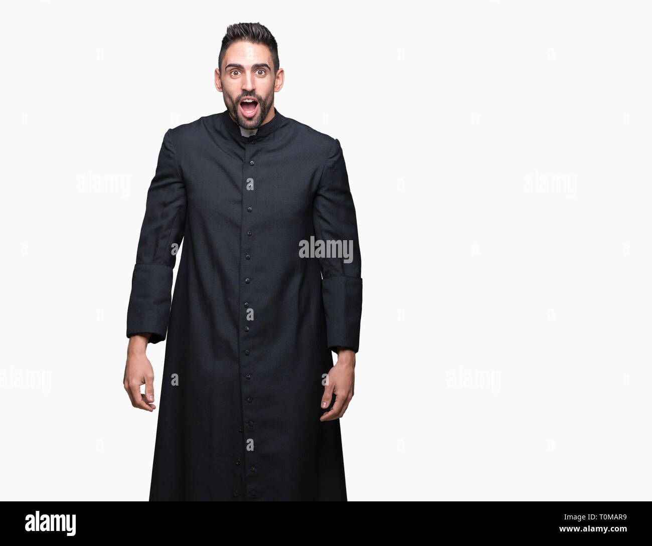 Young Christian priest over isolated background In shock face, looking ...