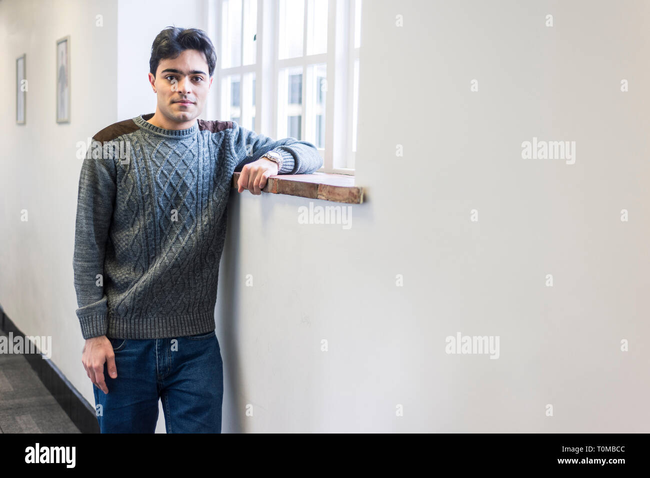 an international happy and confident student in the hallway of a ...