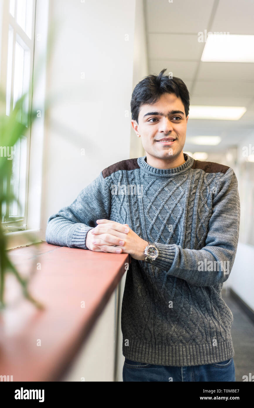 an international happy and confident student in the hallway of a ...