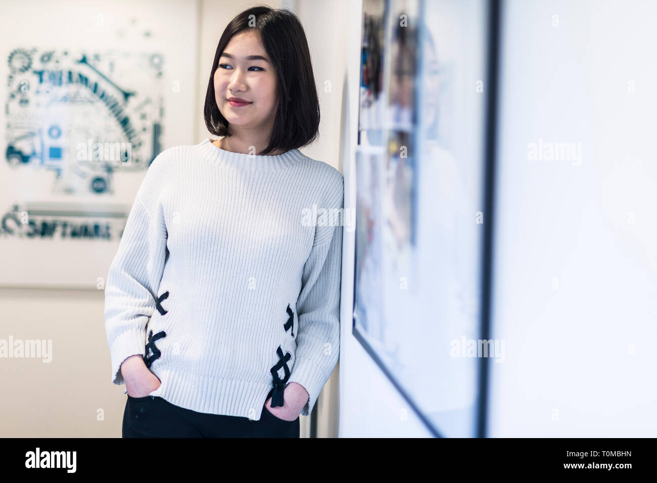 a female asian international student stands in the corridor of a ...