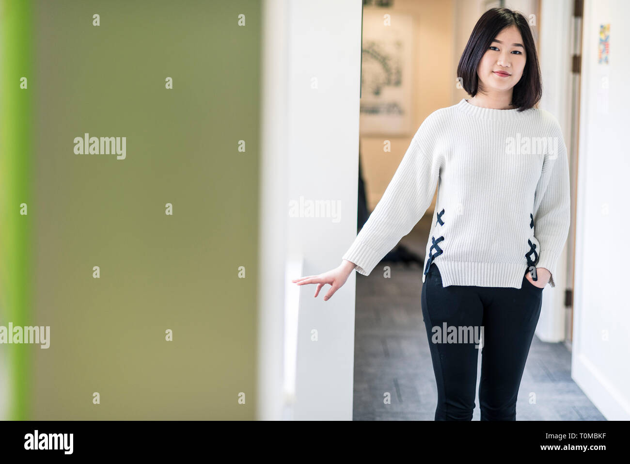a female asian international student stands in the corridor of a ...