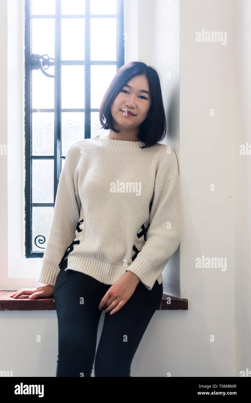 a female asian international student stands in the corridor of a ...