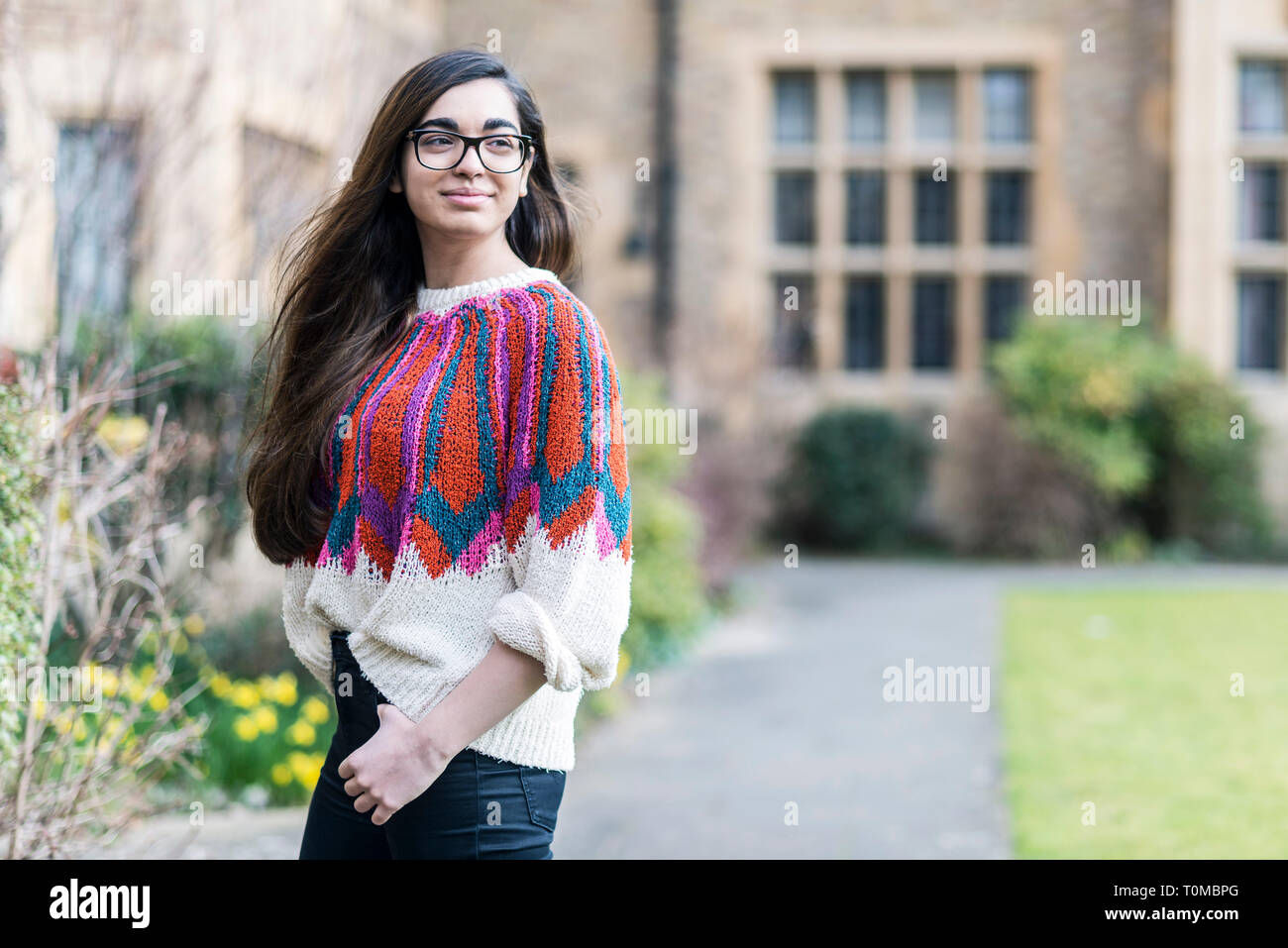 A young international student stands in the campus grounds of a ...