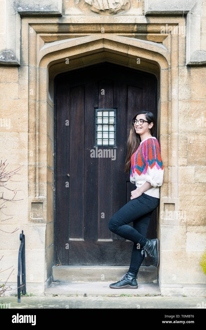A young international student stands in the campus grounds of a ...