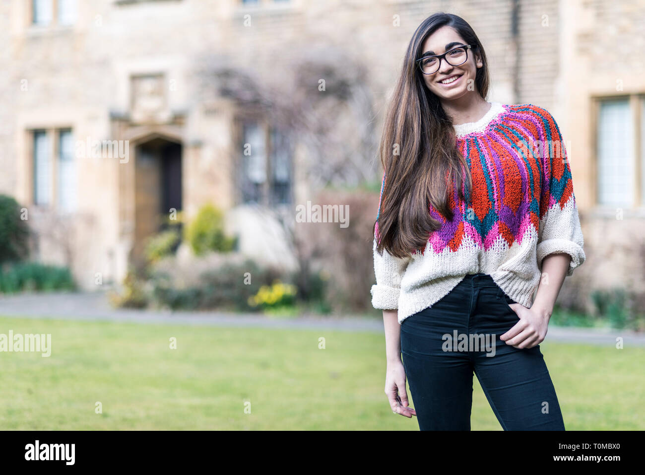 A young international student stands in the campus grounds of a ...
