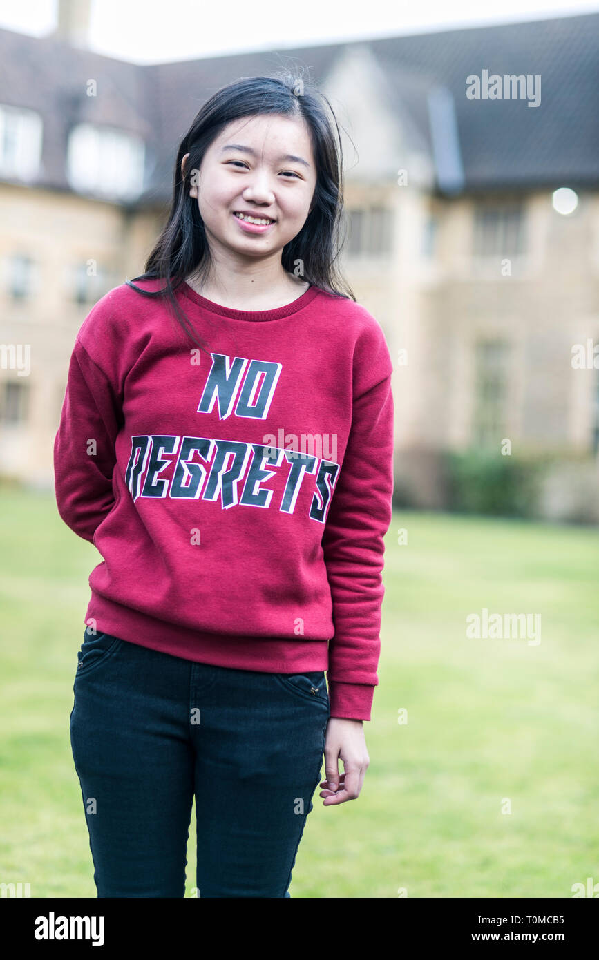 A young international student stands in the campus grounds of a ...