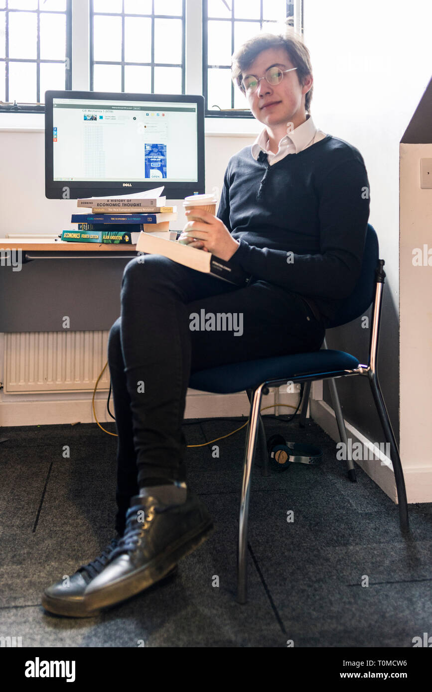 An eastern european student sits at a desk in the library in a ...