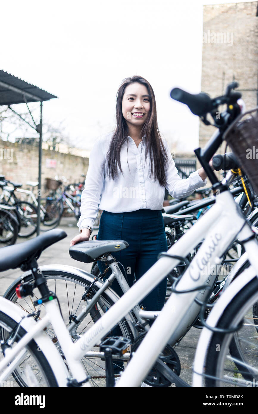 an international student stands amongst the bike storage and many ...