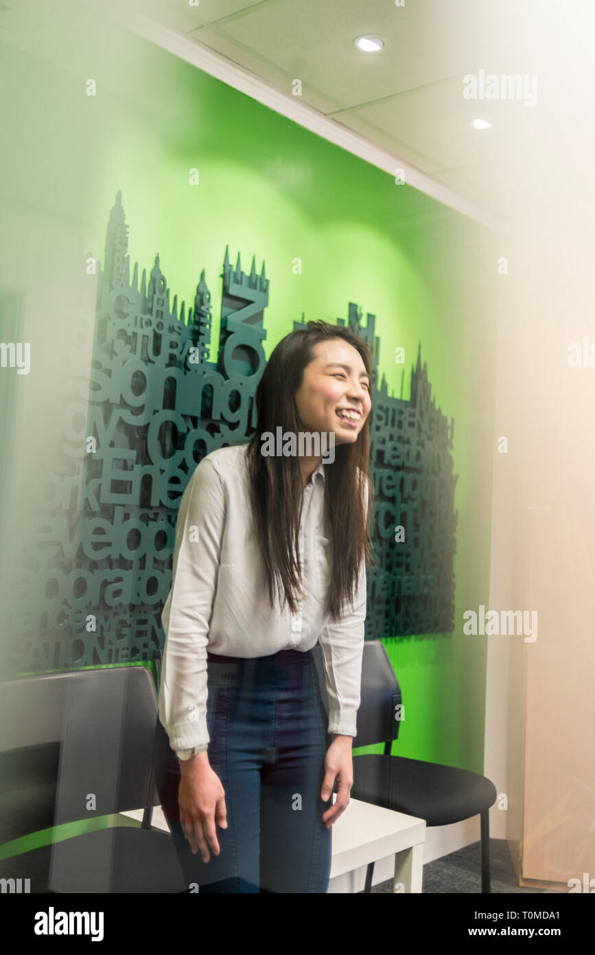 a female asian international student stands in the corridor of a ...