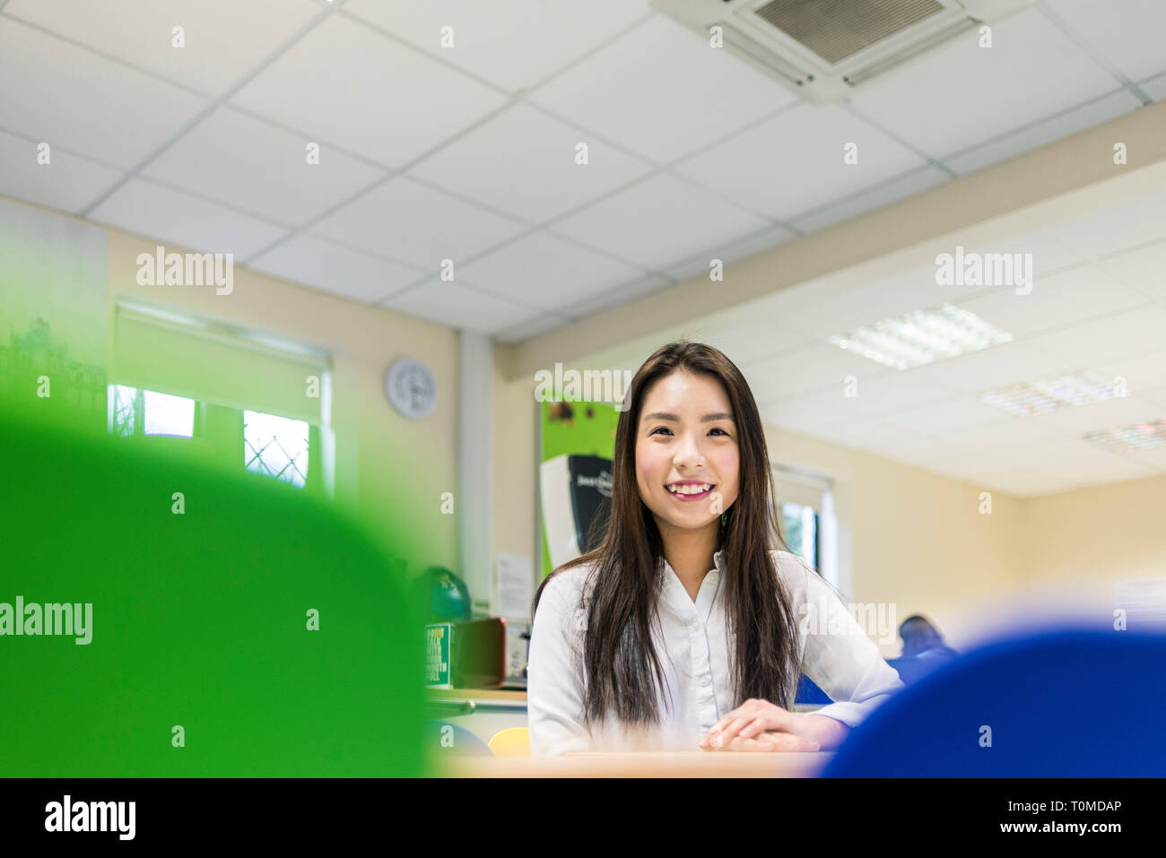 a female asian international student stands in the corridor of a ...