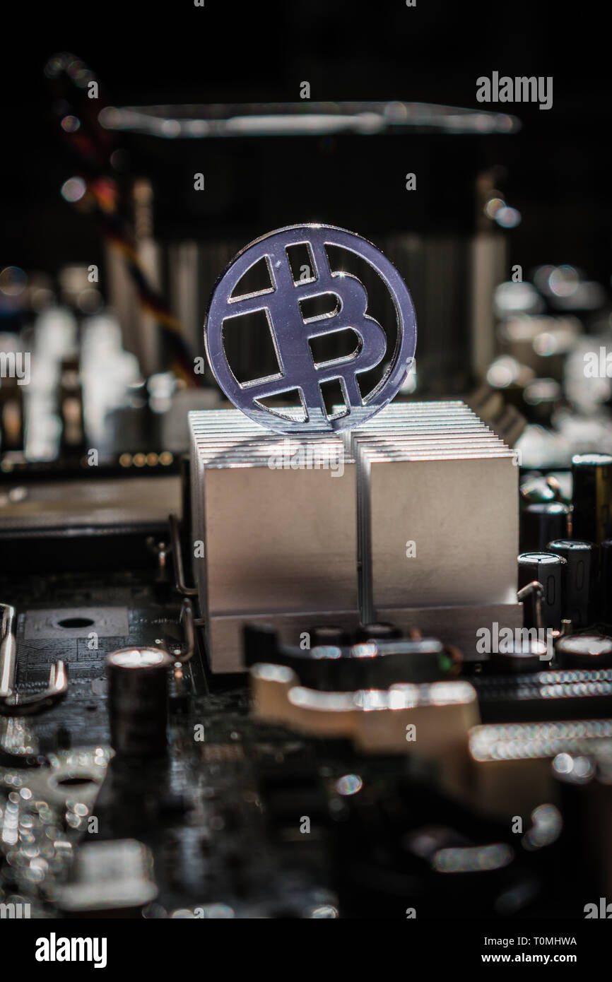 Plastic clear bit coin with motherboard and electronic background and ...
