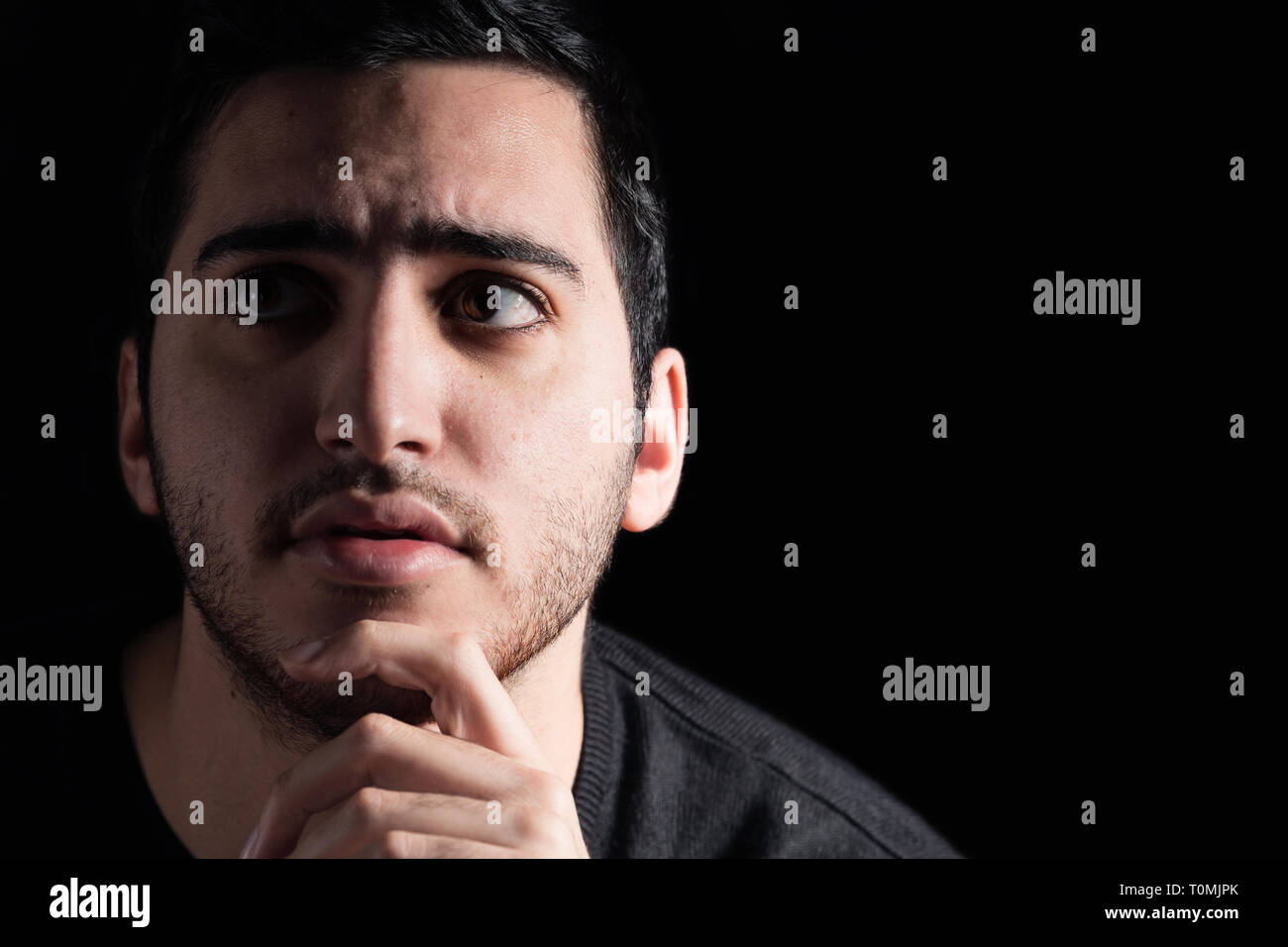 Young Man Looking confused and concerned in the dark Stock Photo - Alamy