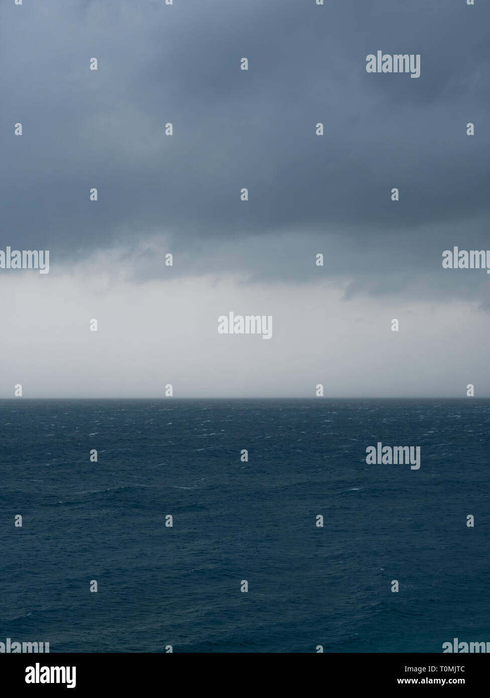 Rough weather with rainy clouds on blue sea Stock Photo - Alamy