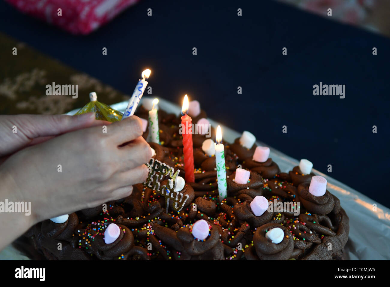 close up - Lighting up candles on a birthday cake Stock Photo - Alamy